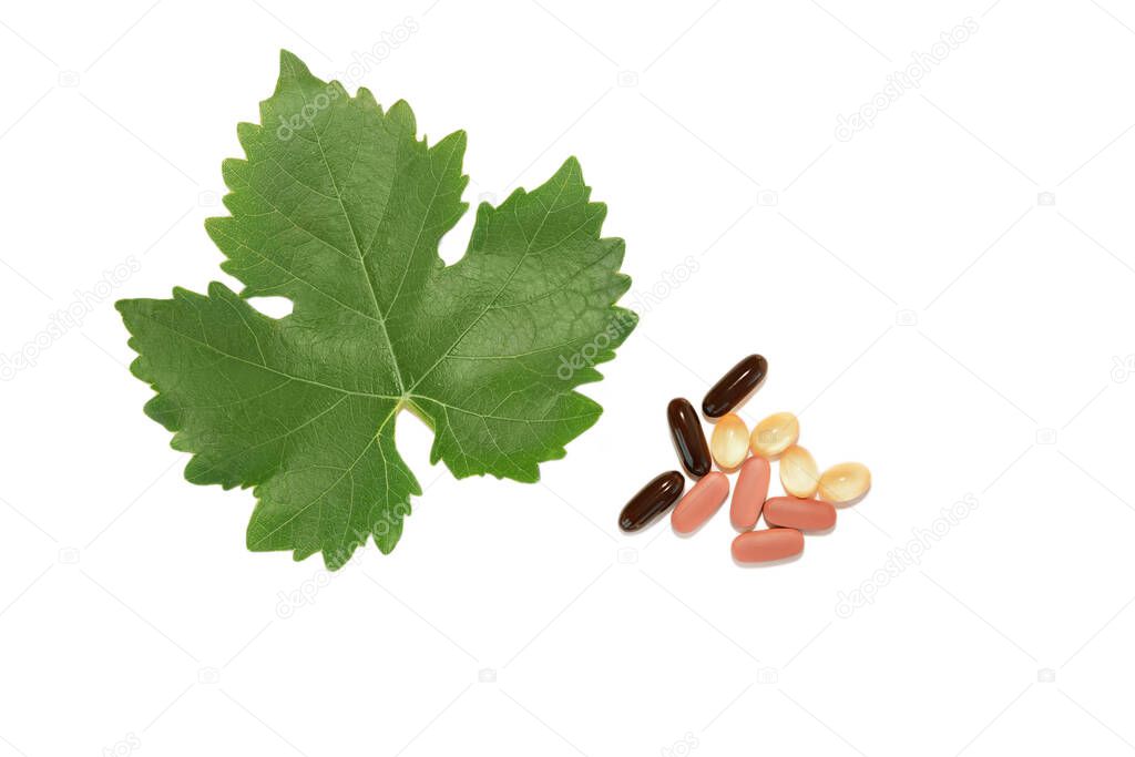 Variedad de píldoras vitamínicas sobre fondo blanco con hoja verde ...