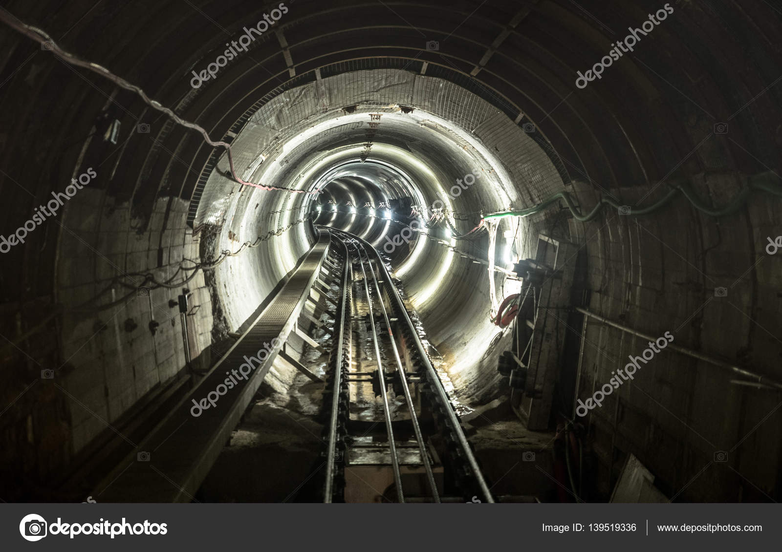 Underground mine pit tunnel gallery with working rail tracks ...