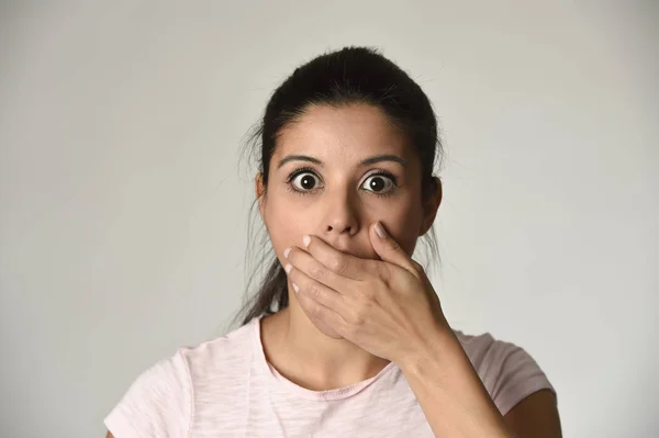 Young beautiful Spanish surprised woman amazed in shock and surprise covering mouth Stock Photo ...
