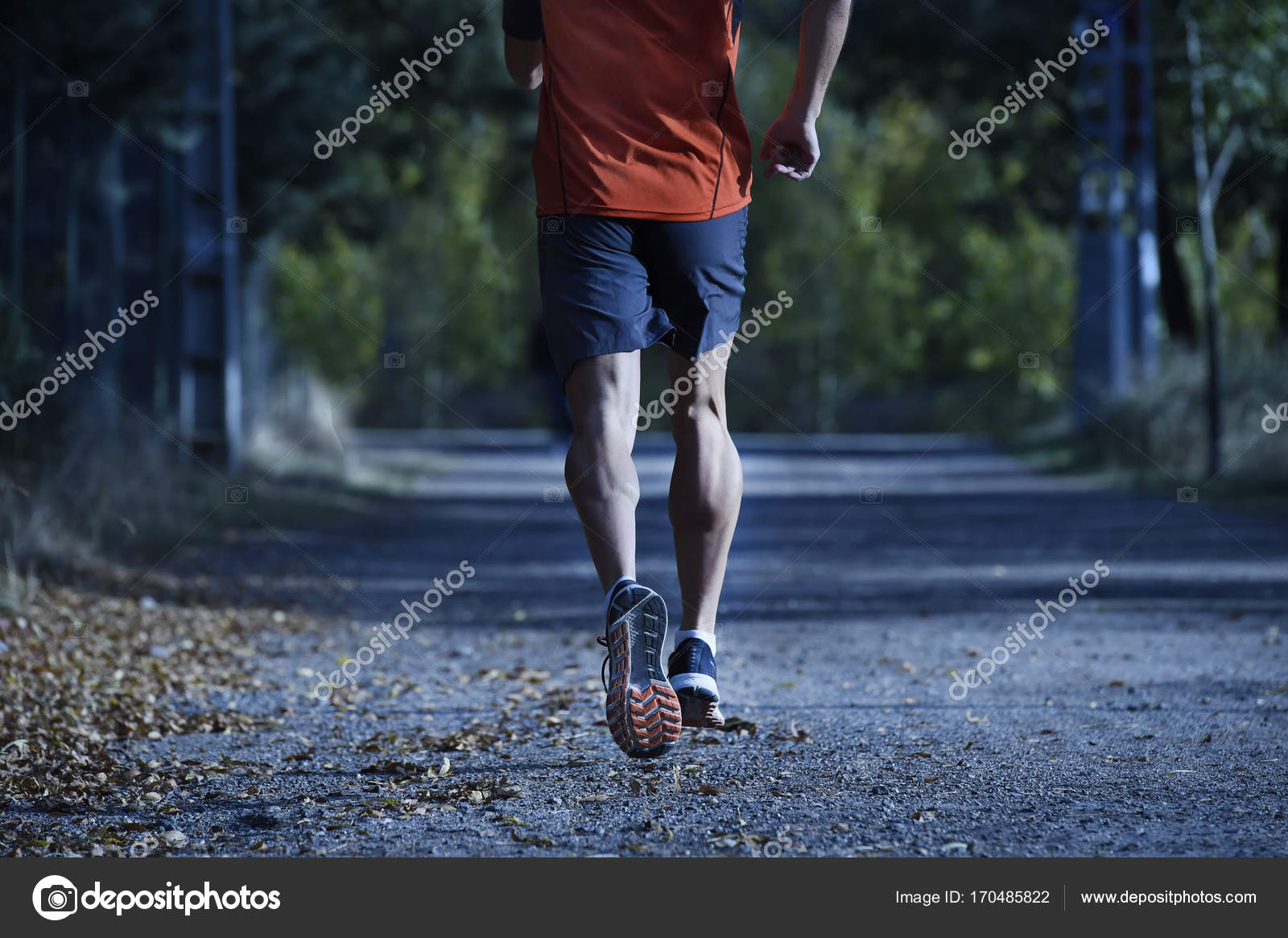 Sport man with ripped athletic and muscular legs running off road in ...