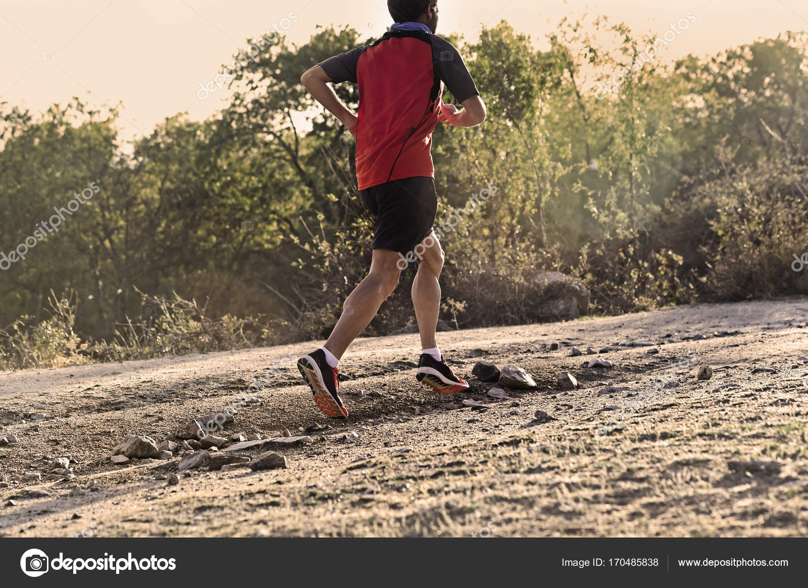 Sport man with ripped athletic and muscular legs running uphill off ...