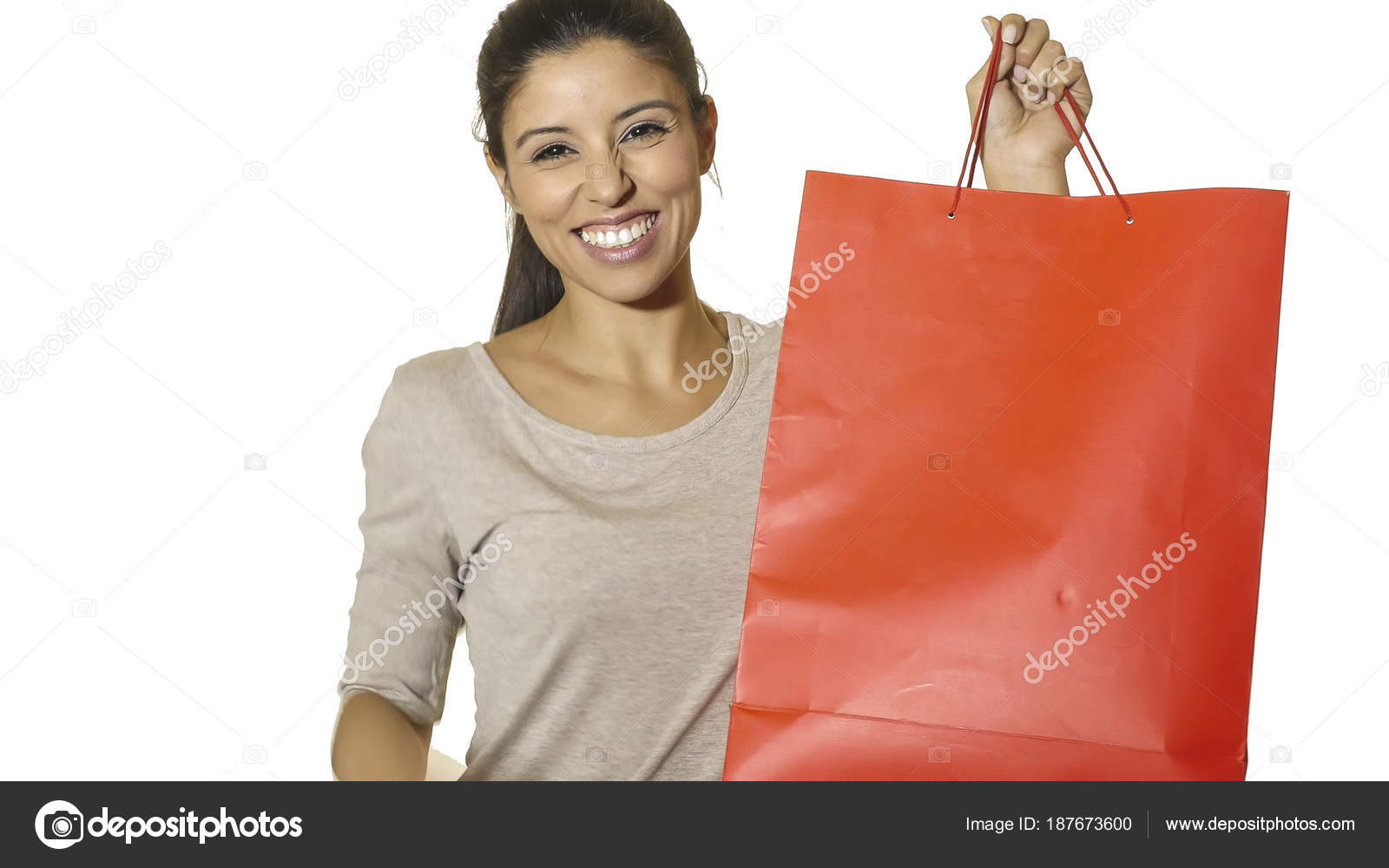 Young Attractive And Happy Latin Woman Holding Red Shopping Bag Smiling