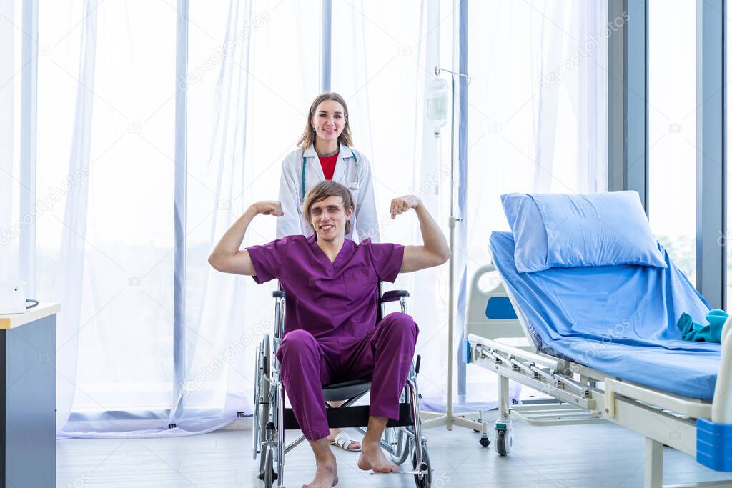 un paciente hombre sentado en una silla de ruedas muestran los pulgares hacia arriba con la cara ...