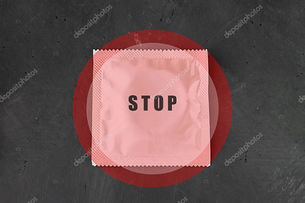 Condón con señal de stop rojo en el fondo de chaklboard negro. Concebir ...