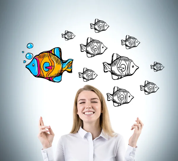 Woman with crossed fingers and fish sketches on gray wall - Stock Image ...