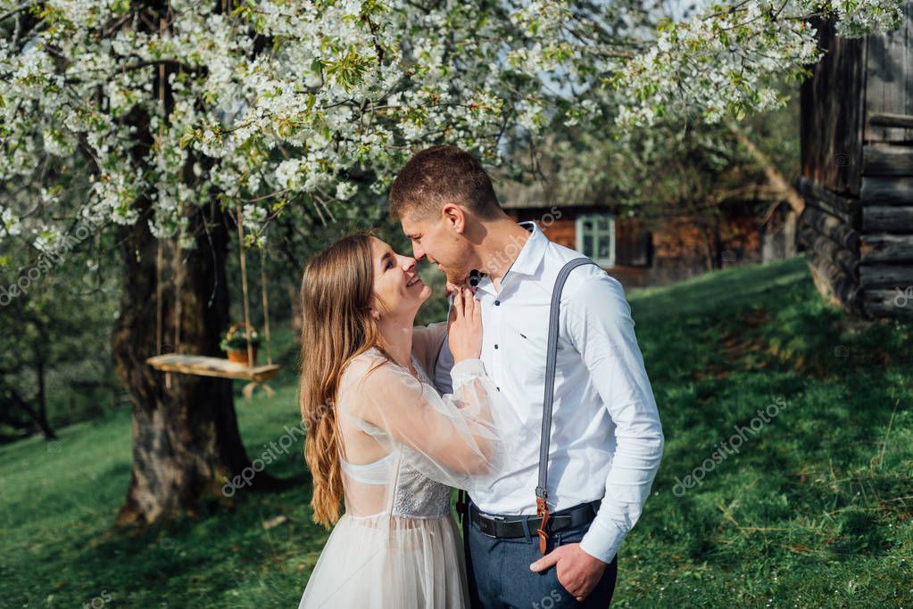 Novia y novio en el día de la boda caminando al aire libre en la naturaleza de primavera. Pareja ...