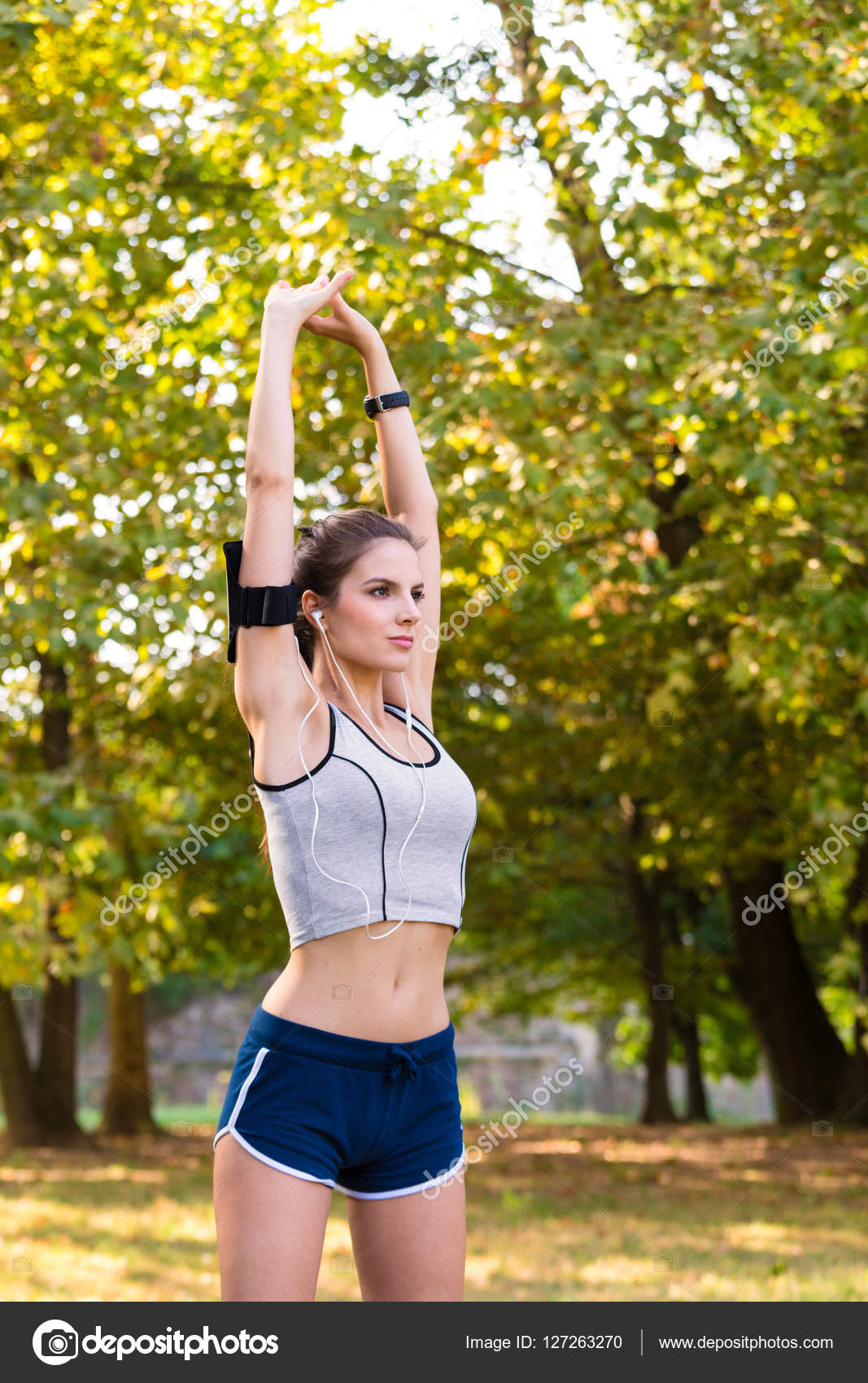 Female runner stretches her arms during Warm up Stock Photo by ...