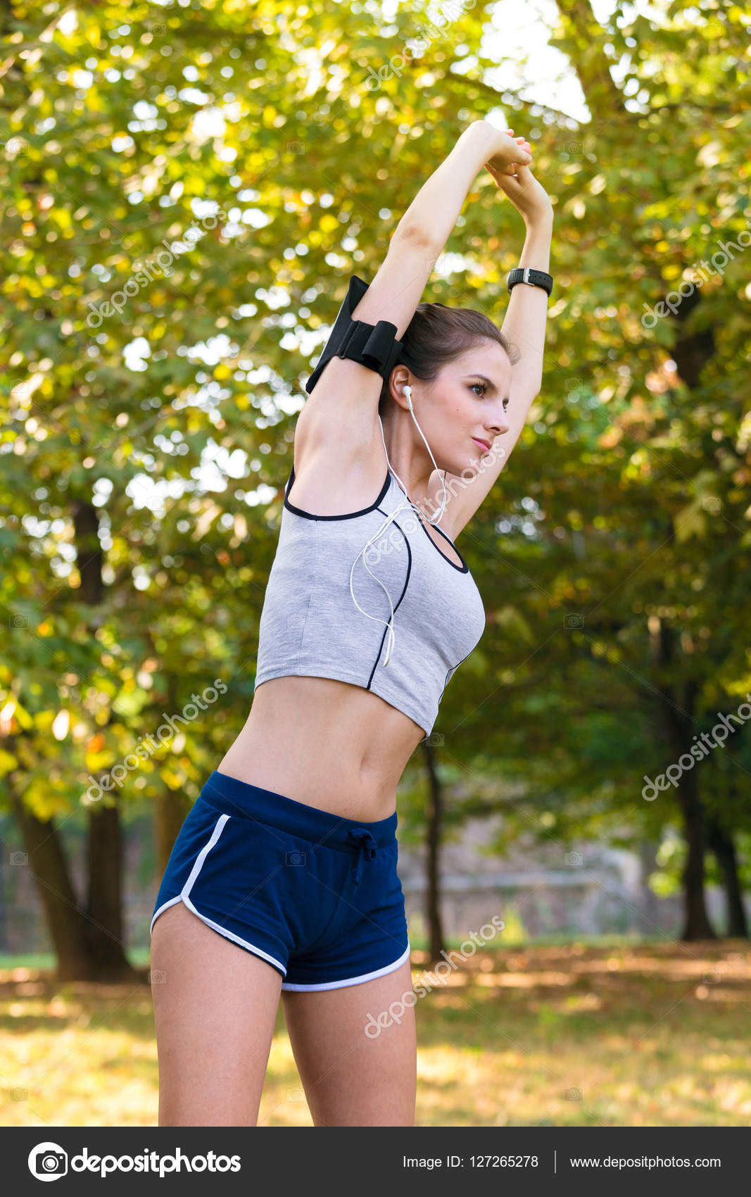 Female runner stretches her arms during Warm up Stock Photo by ...