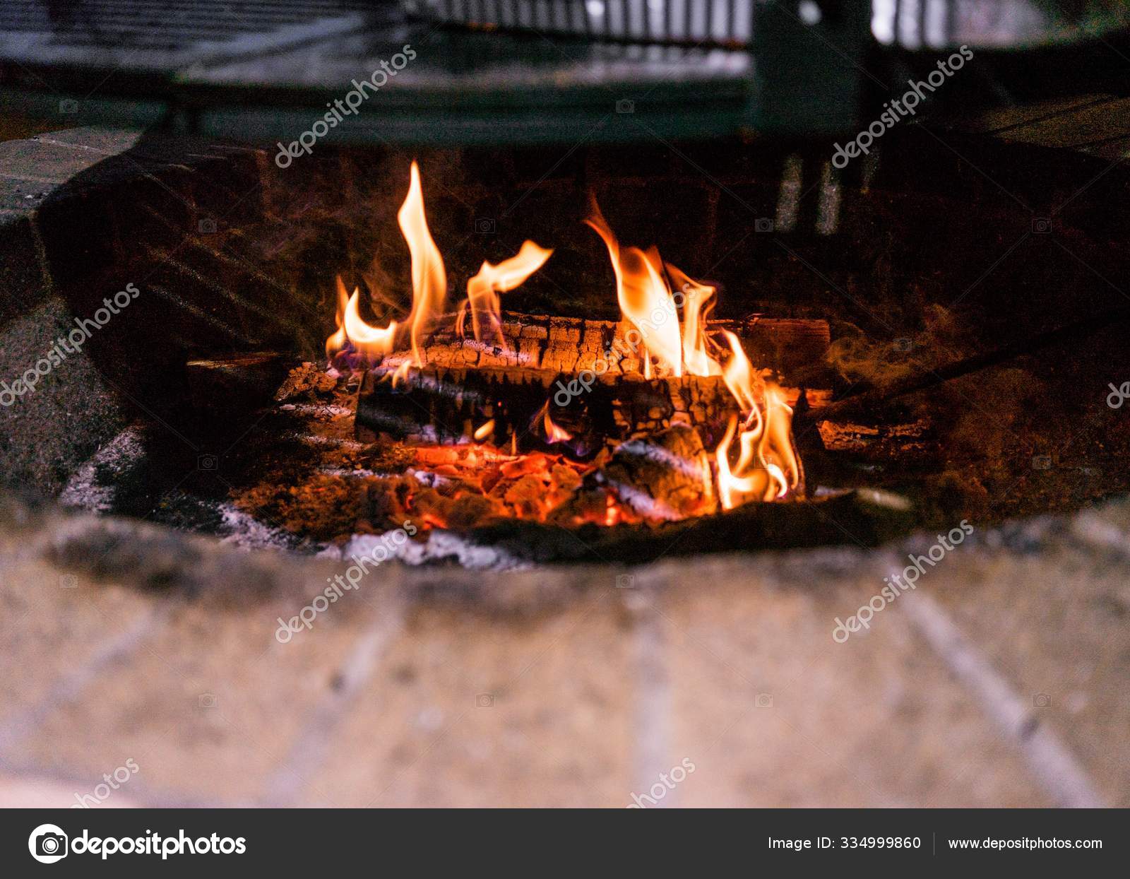 Close up shot of a fire in a brick fire pit — Stock Photo © Wirestock ...