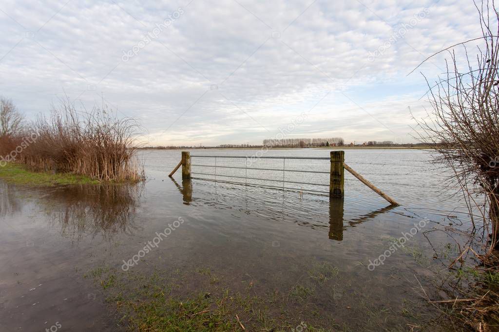 Las tierras de cultivo inundadas por un río bajo un cielo nublado en ...