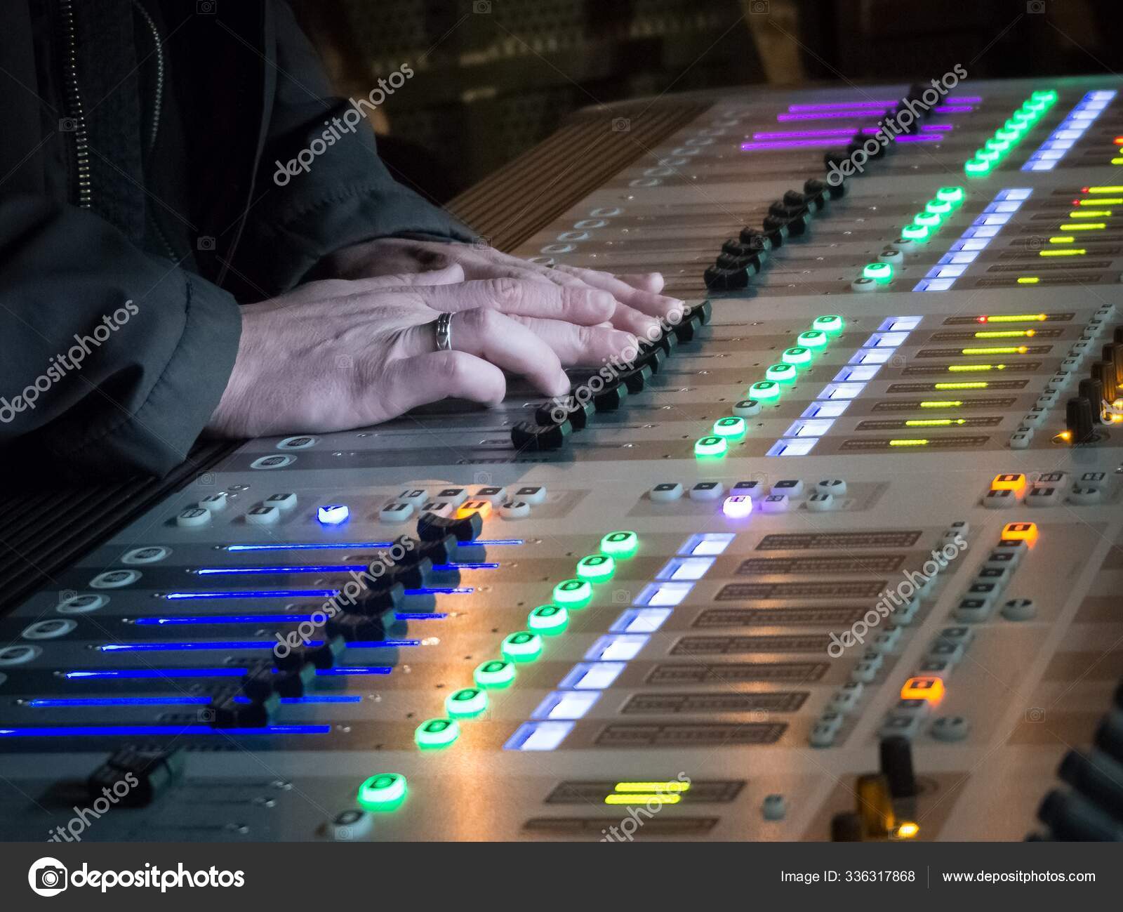 Person controlling the control panel of a digital studio mixer at a ...