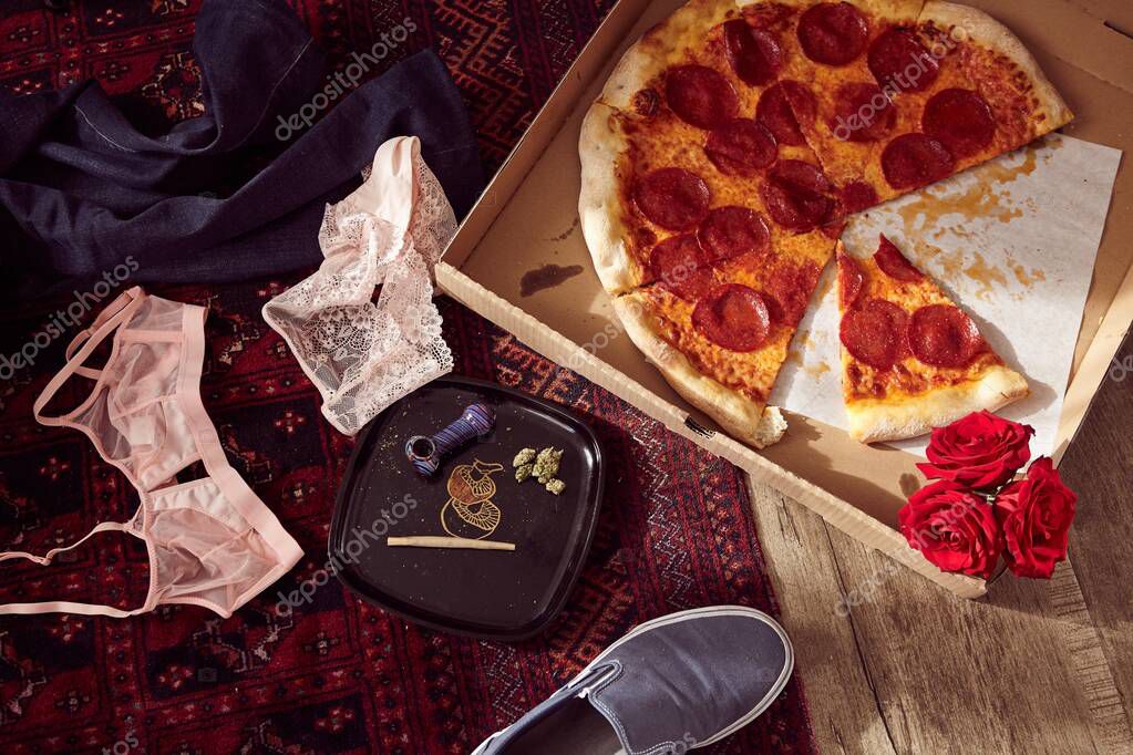 Pizza de pepperoni medio comido en el suelo con ropa interior de mujer ...