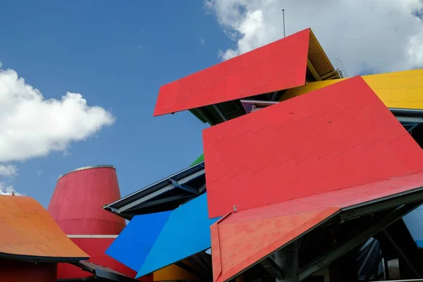 Un primer plano del Biomuseo bajo la luz del sol y un cielo azul ...
