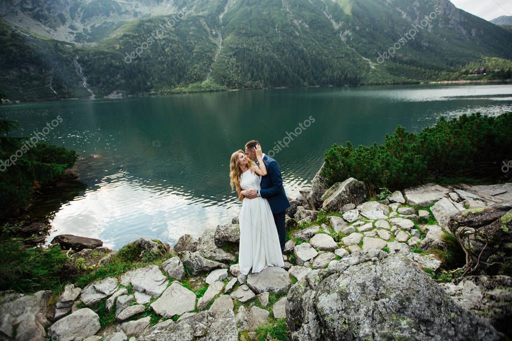 Feliz novia y novio en su boda. El novio besa la frente de la novia. Retrato de la novia. Recién ...
