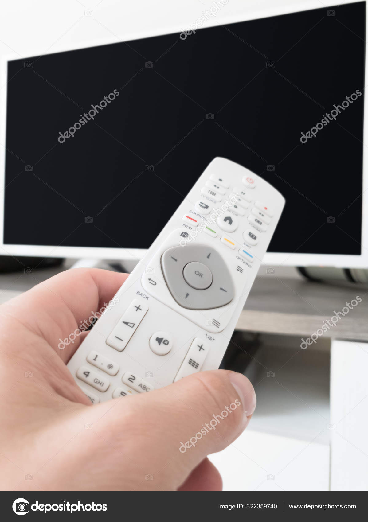 Hand holding TV remote controller with a modern television set. Stock ...