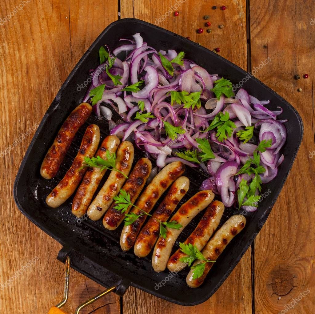 Embutidos fritos con cebolla y perejil en una sart n sobre fondo de ...