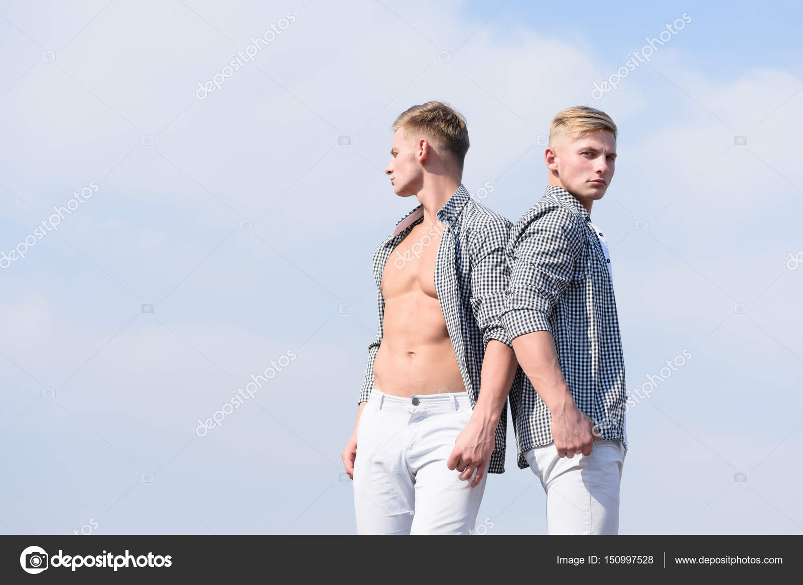 Handsome twins posing with serious faces on sky background Stock Photo ...