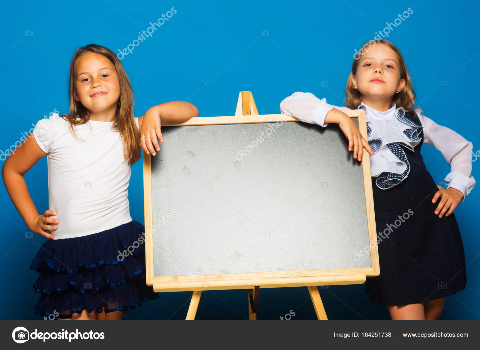 Schoolgirls with smiling faces stand near blackboard Stock Photo by ...