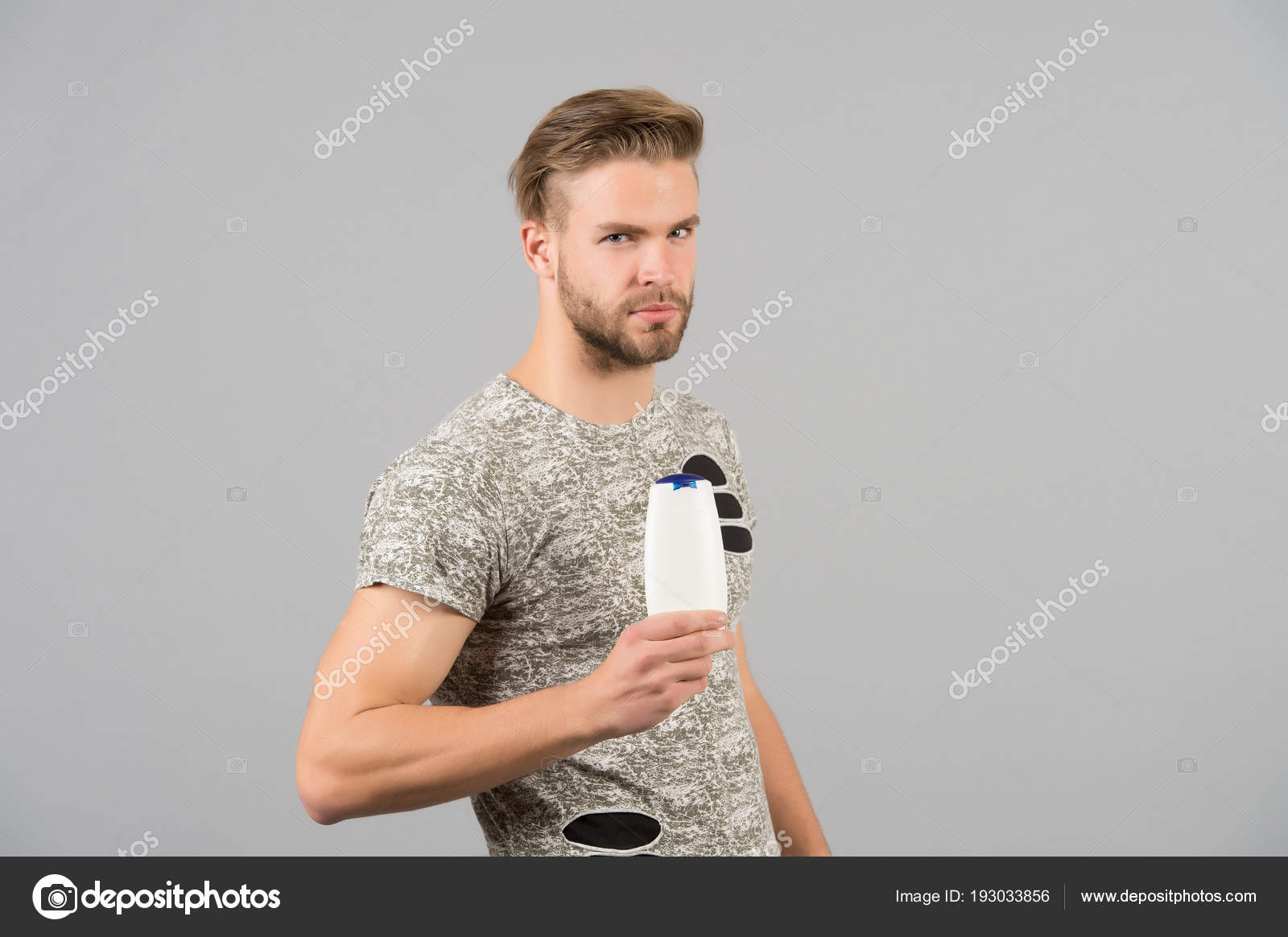 Man with shampoo or gel bottle in hand. Macho with stylish hair ...