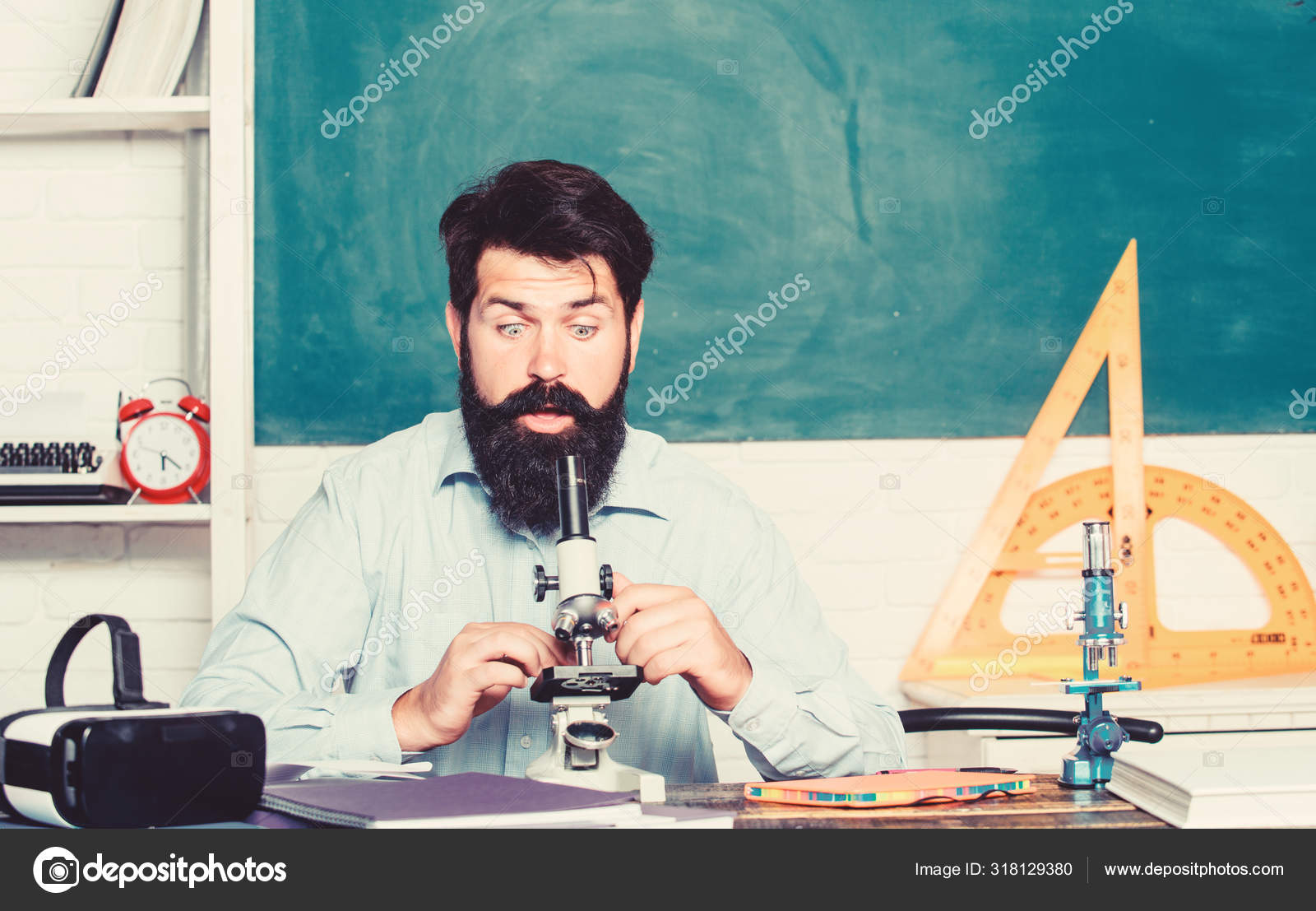 School teacher looking microscope. Fascinating research. Set up ...