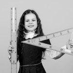 Kid school uniform hold ruler. Pupil cute girl with big ruler. Geometry ...