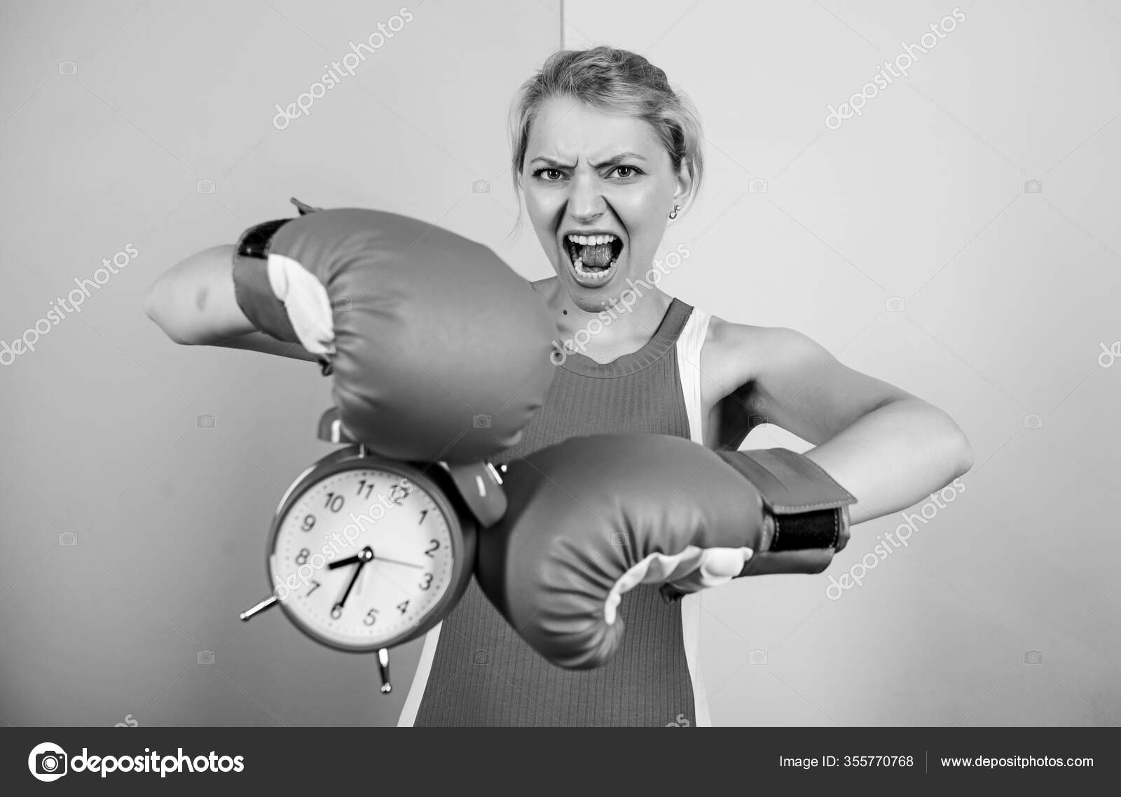Punching a clock. time for success. win the day. angry woman boxing ...