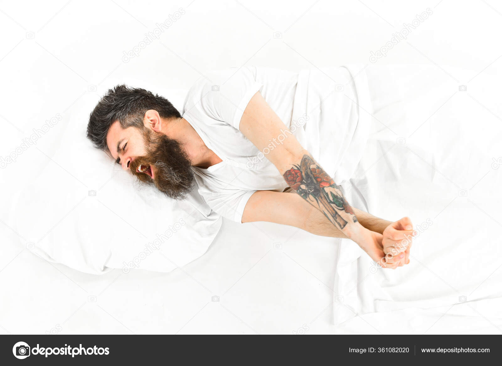 Man with sleepy yawning face stretching while lay in bed Stock Photo by ...