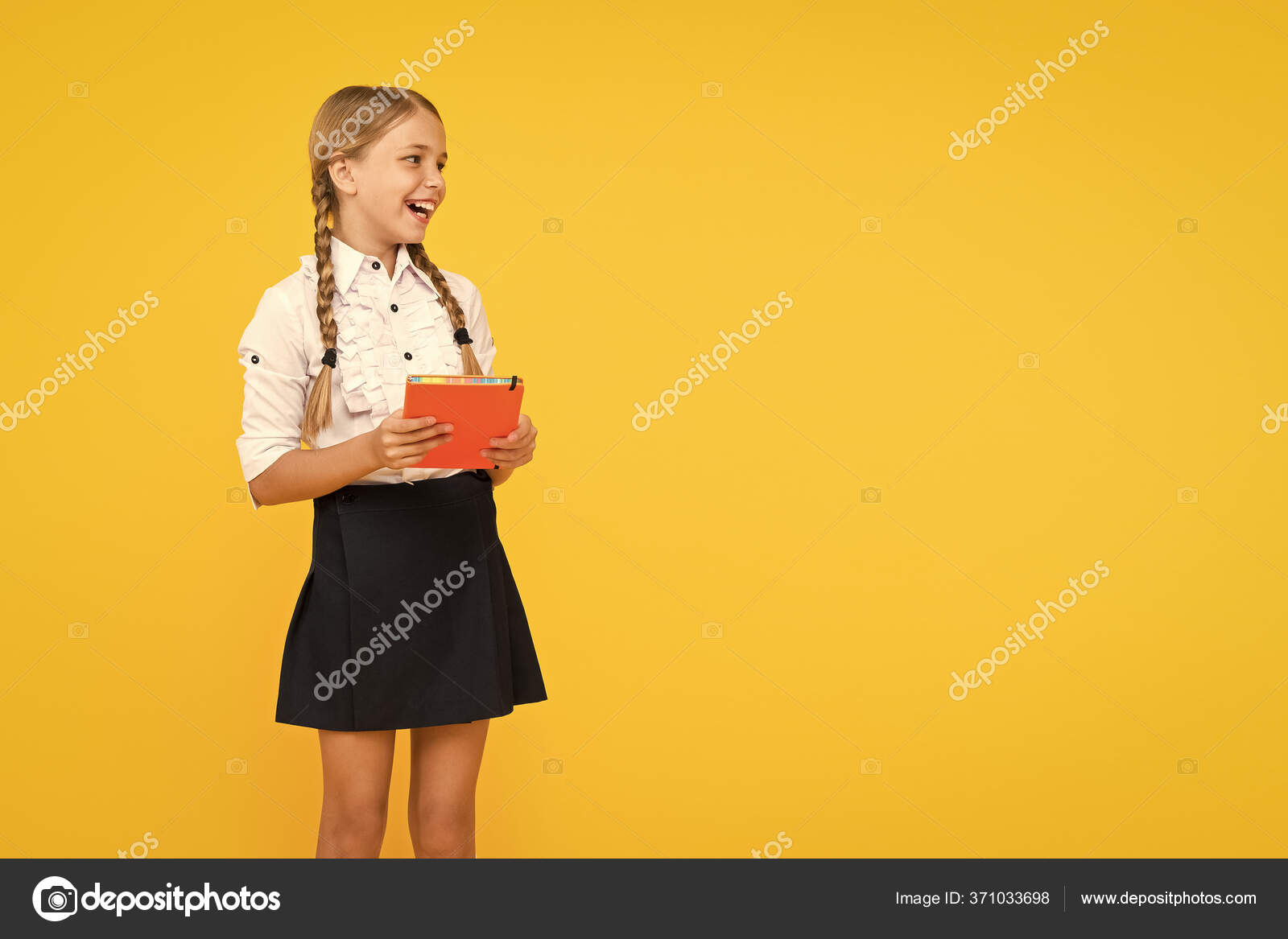 The joy of good knowledge. Cute small girl holding book on yellow ...