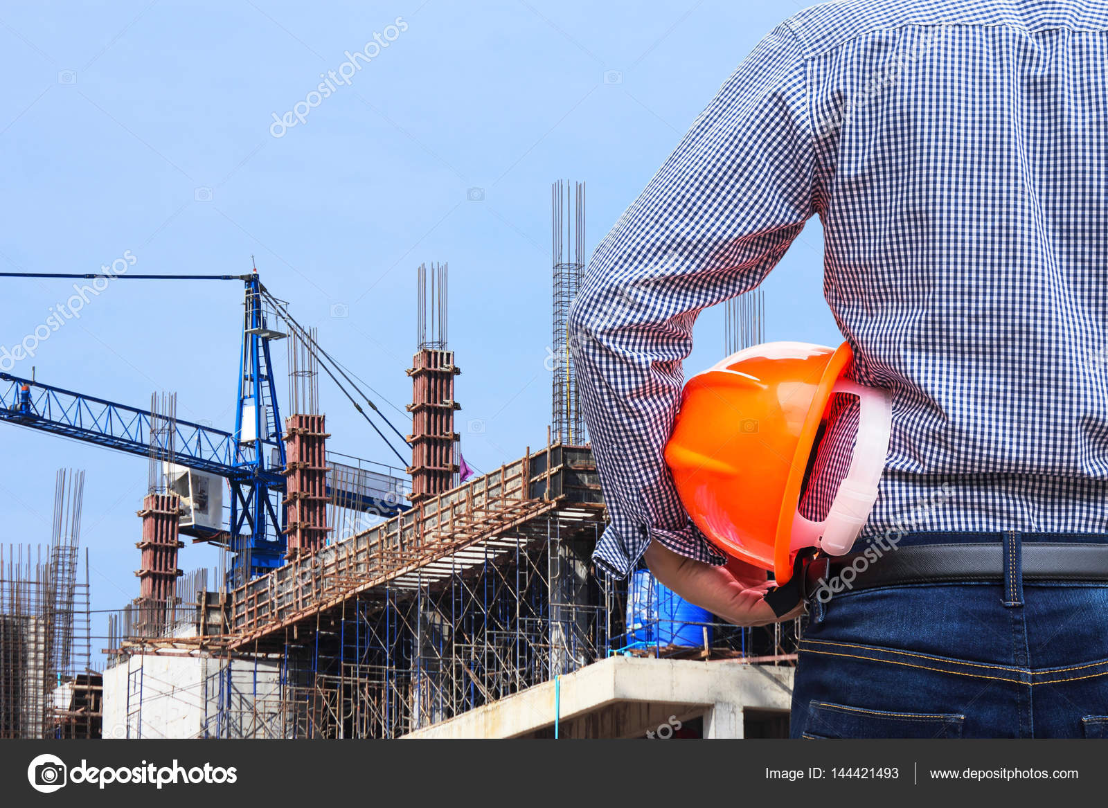 Engineer holding yellow safety helmet in building construction site ...