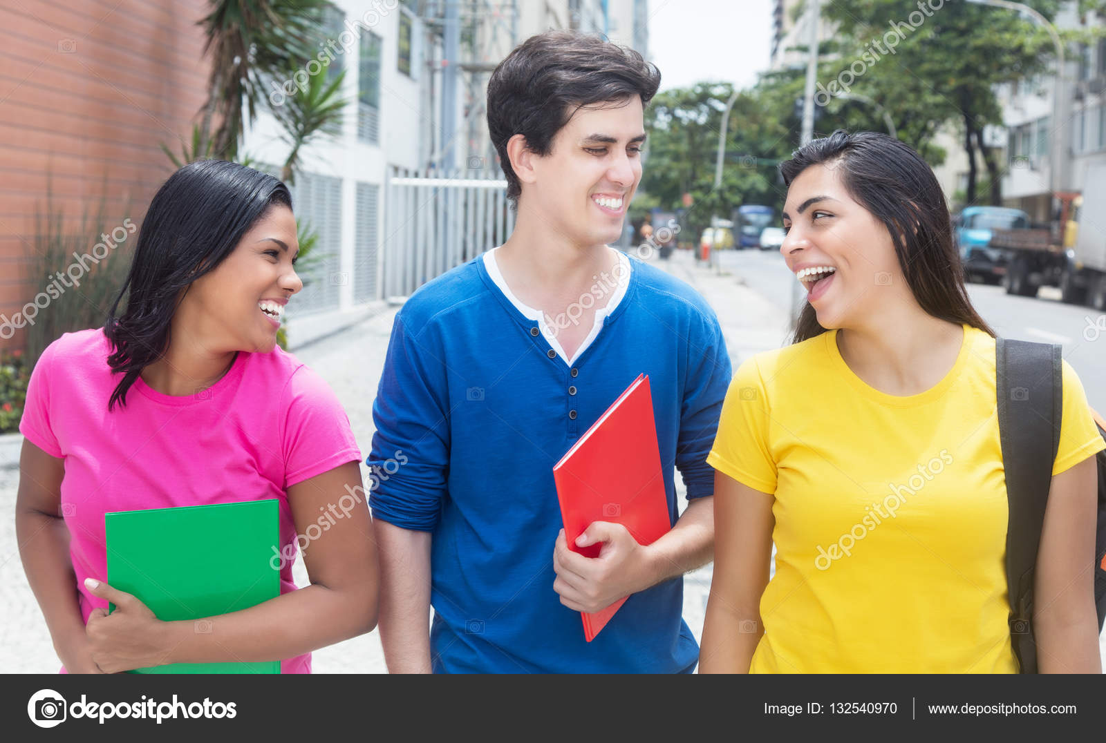 Group of three international students walking in the city Stock Photo ...
