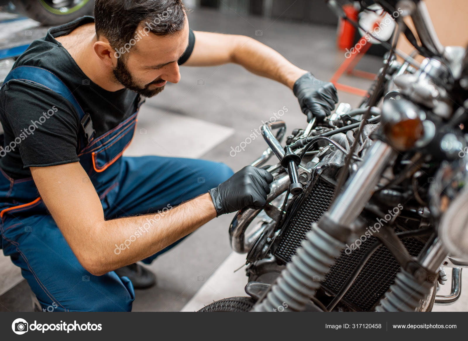 Worker repairing motorcycle engine at the workshop Stock Photo by ...