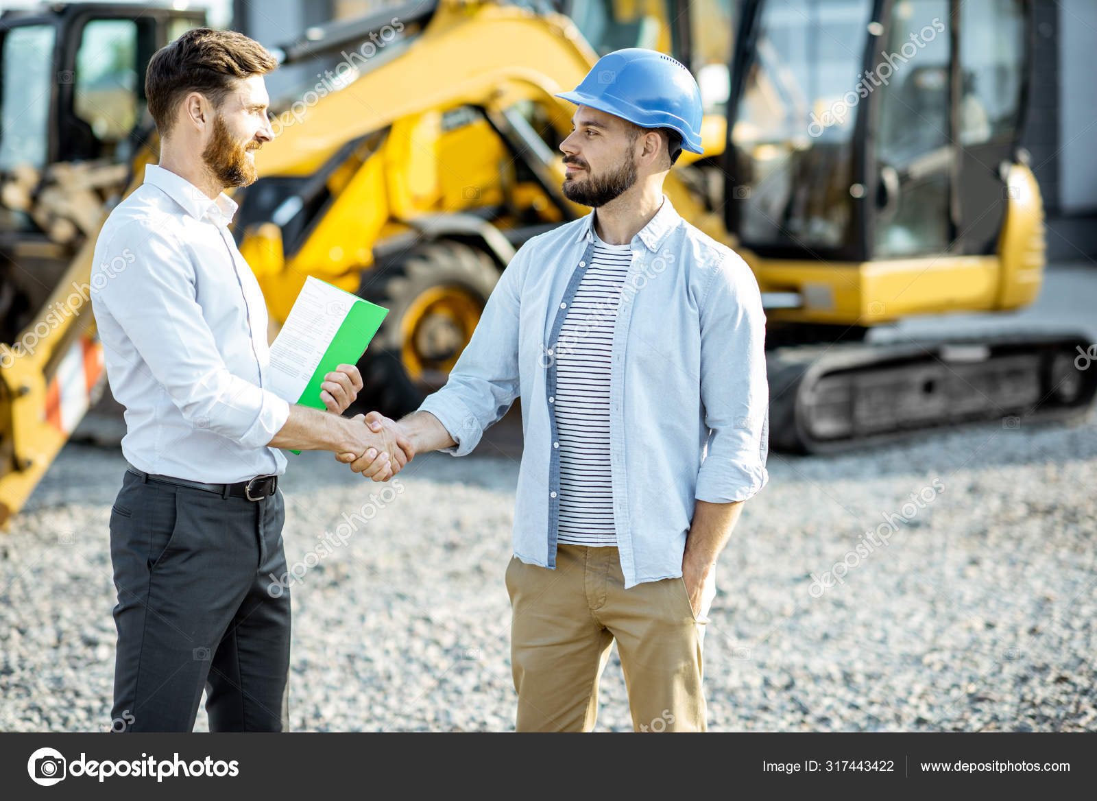 Builder with a sales consultant at the shop with heavy machinery ...