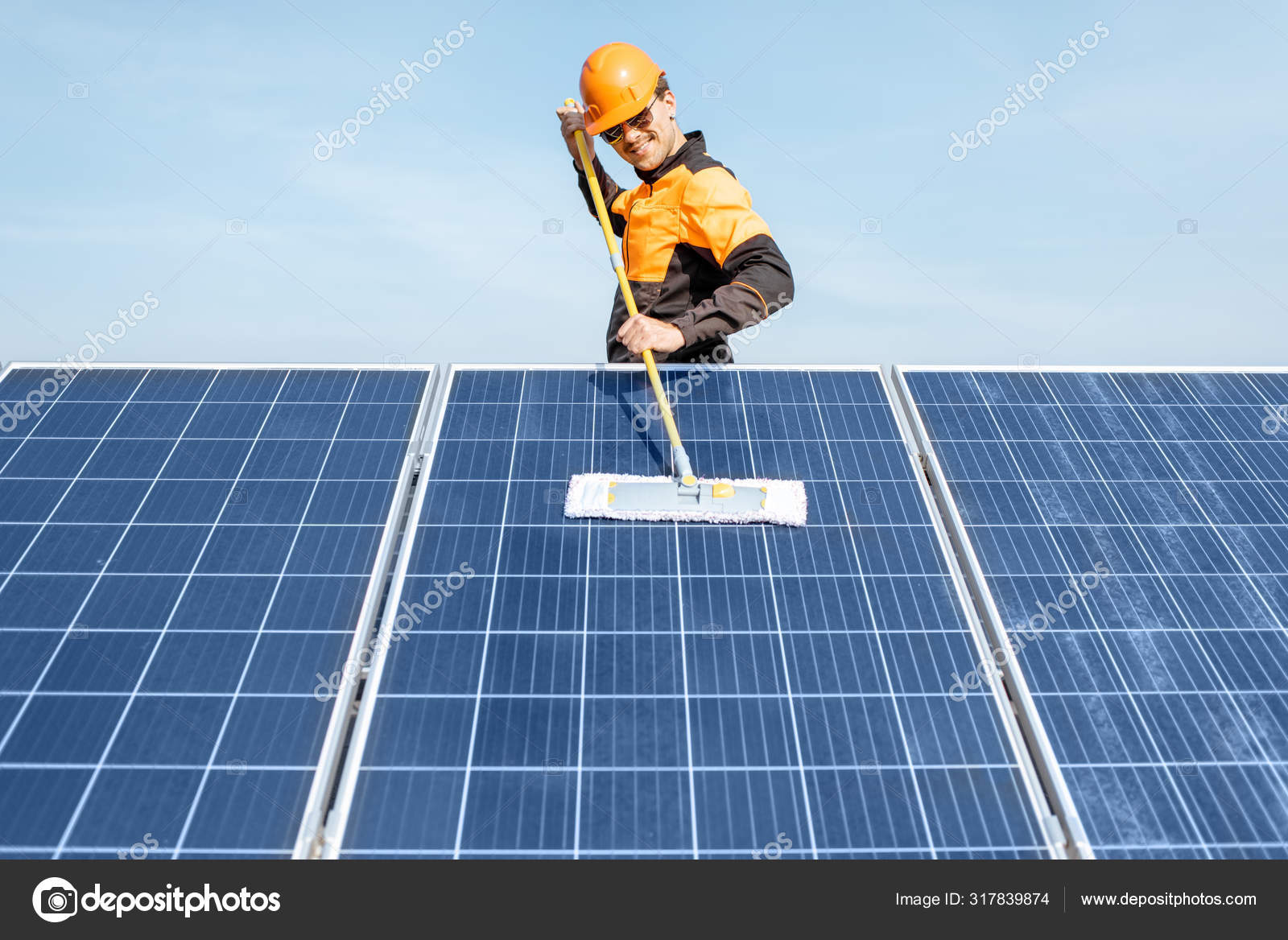 Workman cleaning solar panels Stock Photo by ©rossandhelen 317839874