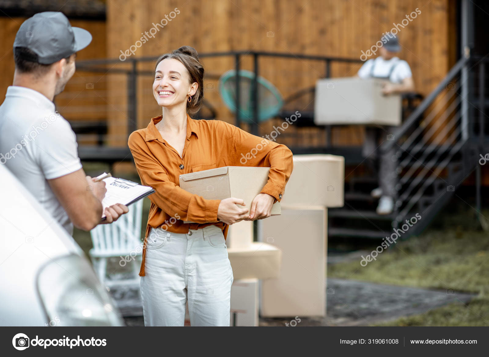 Couriers delivering goods to a woman home — Stock Photo © rossandhelen ...