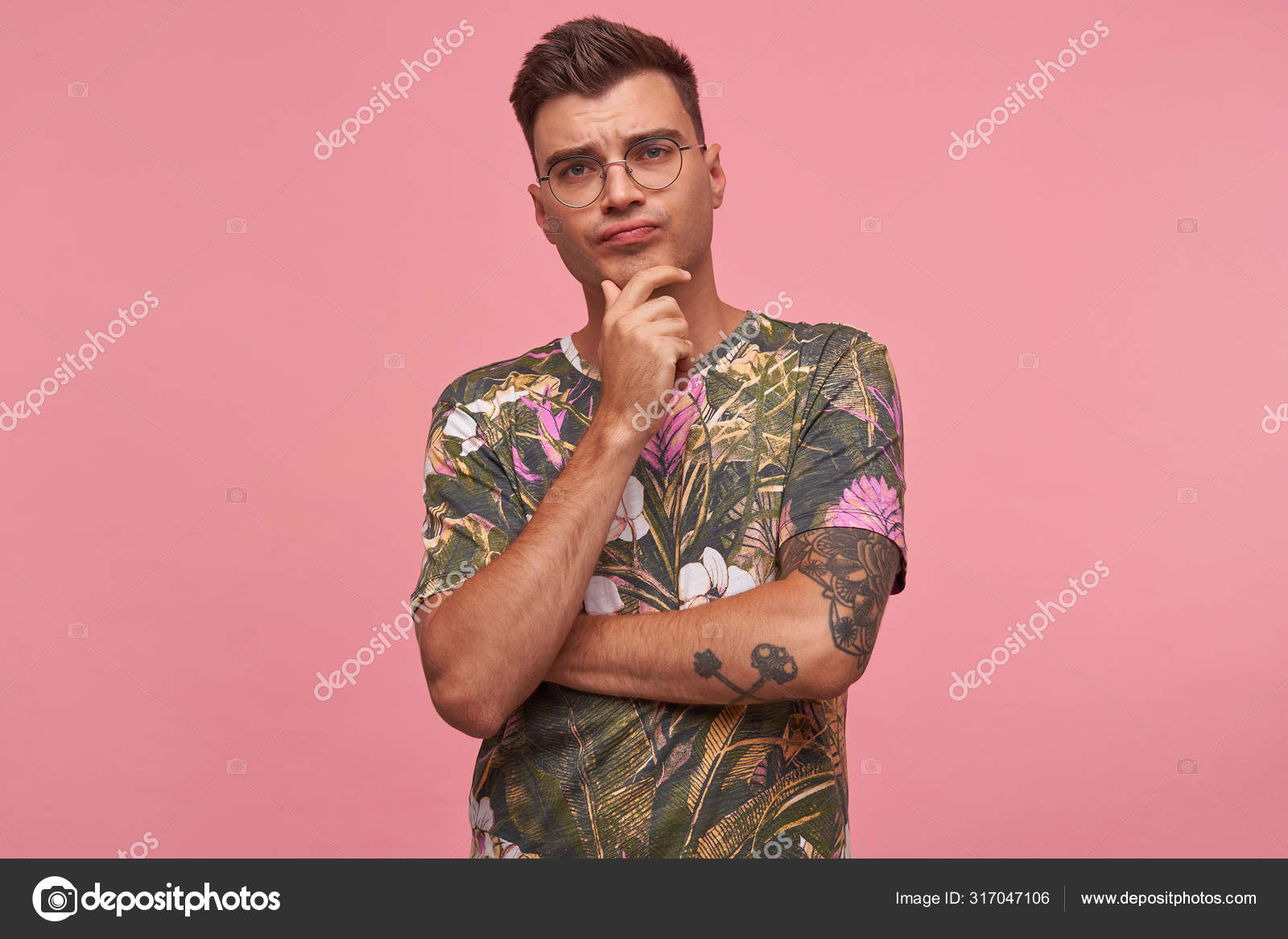 Beautiful young male with trendy haircut and tattoos posing over pink ...