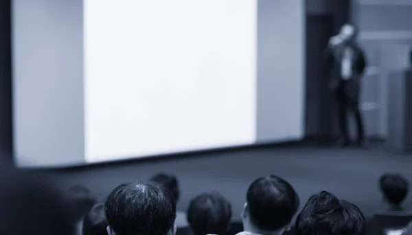 Seminar with expert speaker presenting to audience in hall. Blank ...