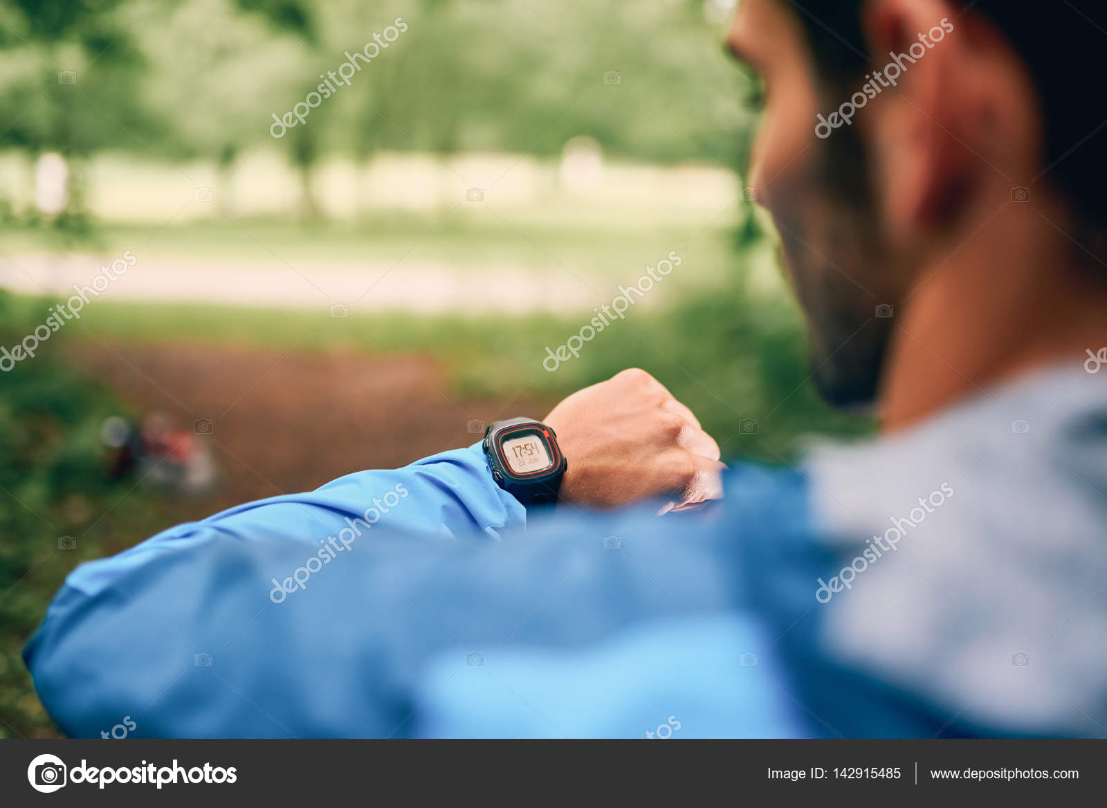 Fit male jogger day using a smartwatch during cross country forest ...