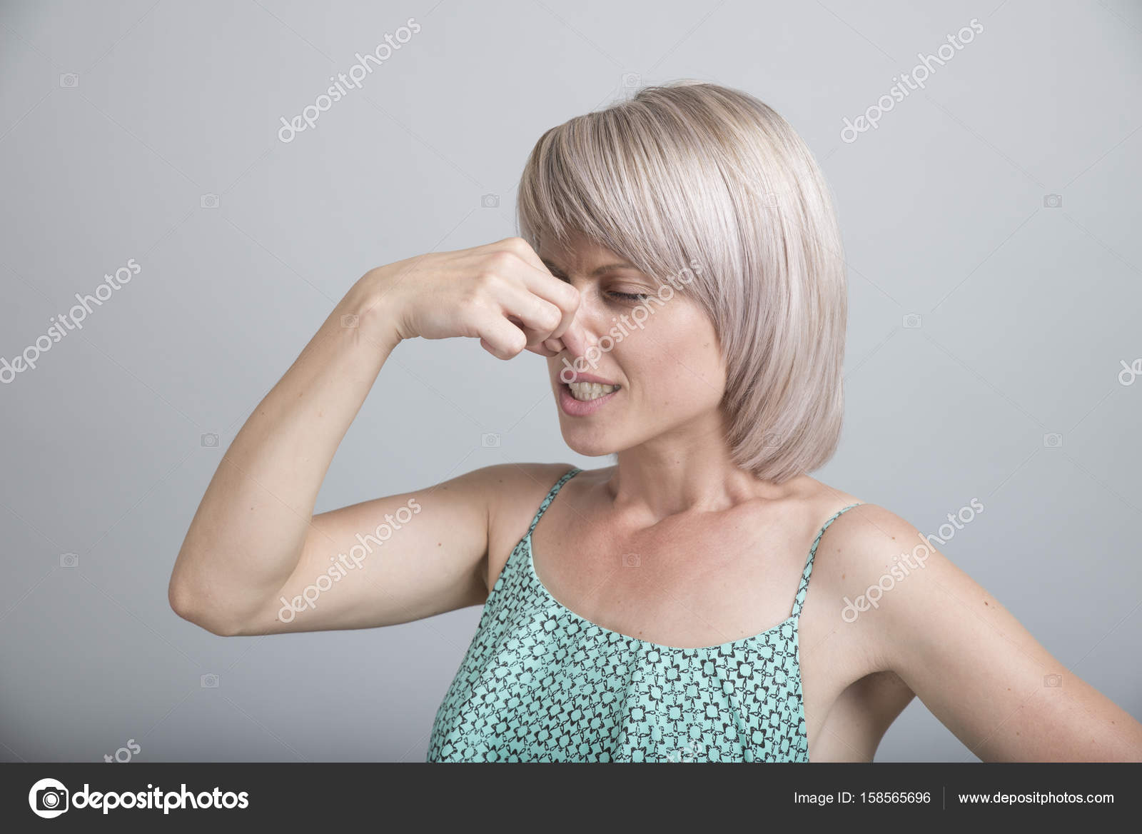 Female gesture smells bad. Portrait of woman wearing casually pinches ... Female gesture smells bad. Portrait of woman wearing casually pinches ...