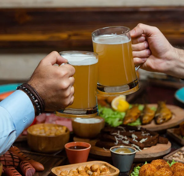 Clinking Beer Mugs Snacks Table — Stock Photo © Farhadib #389806336