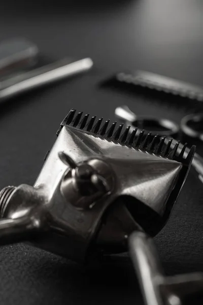 On a black surface are old barber tools. vintage manual hair clipper ...