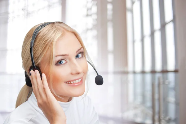 Portrait of happy smiling cheerful beautiful young female support phone operator in headset, at ...