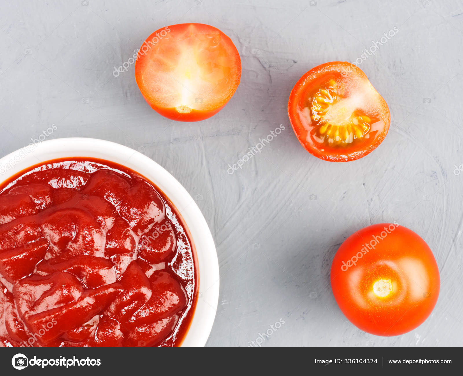 Tomato paste in a white bowl and tomatoes on a gray concrete ba — Stock ...
