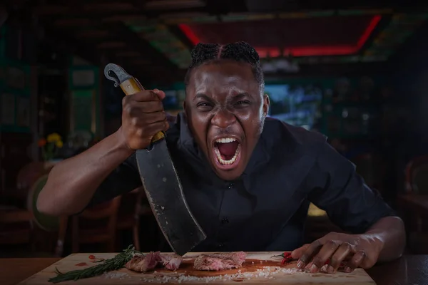 Angry hungry man (boss) with knife and raw bloody meat. Downsizing ...