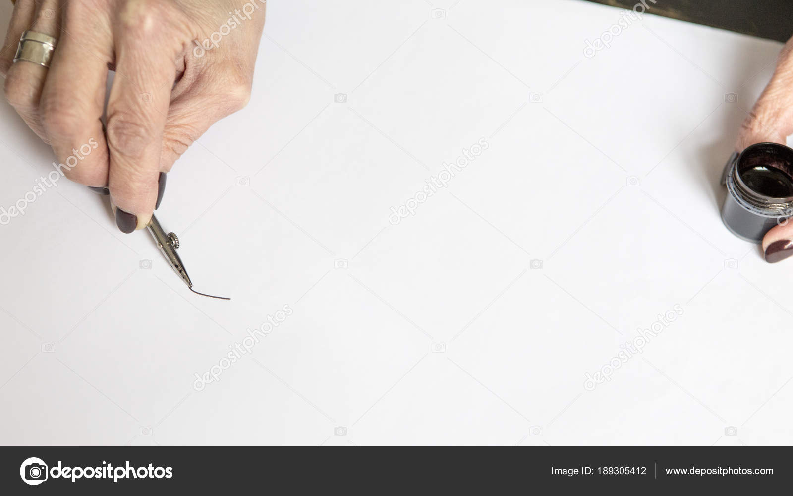 Woman create a calligraphy design work using drawing pen and ink ...