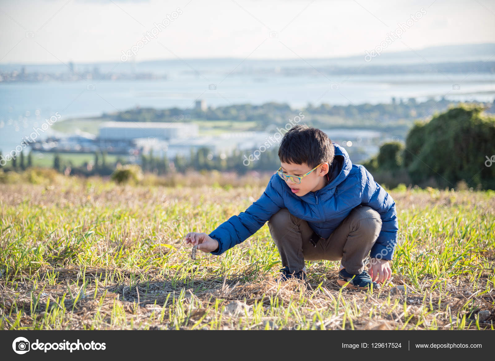 Boy finding stone on the ground Stock Photo by ©parinyabinsuk 129617524
