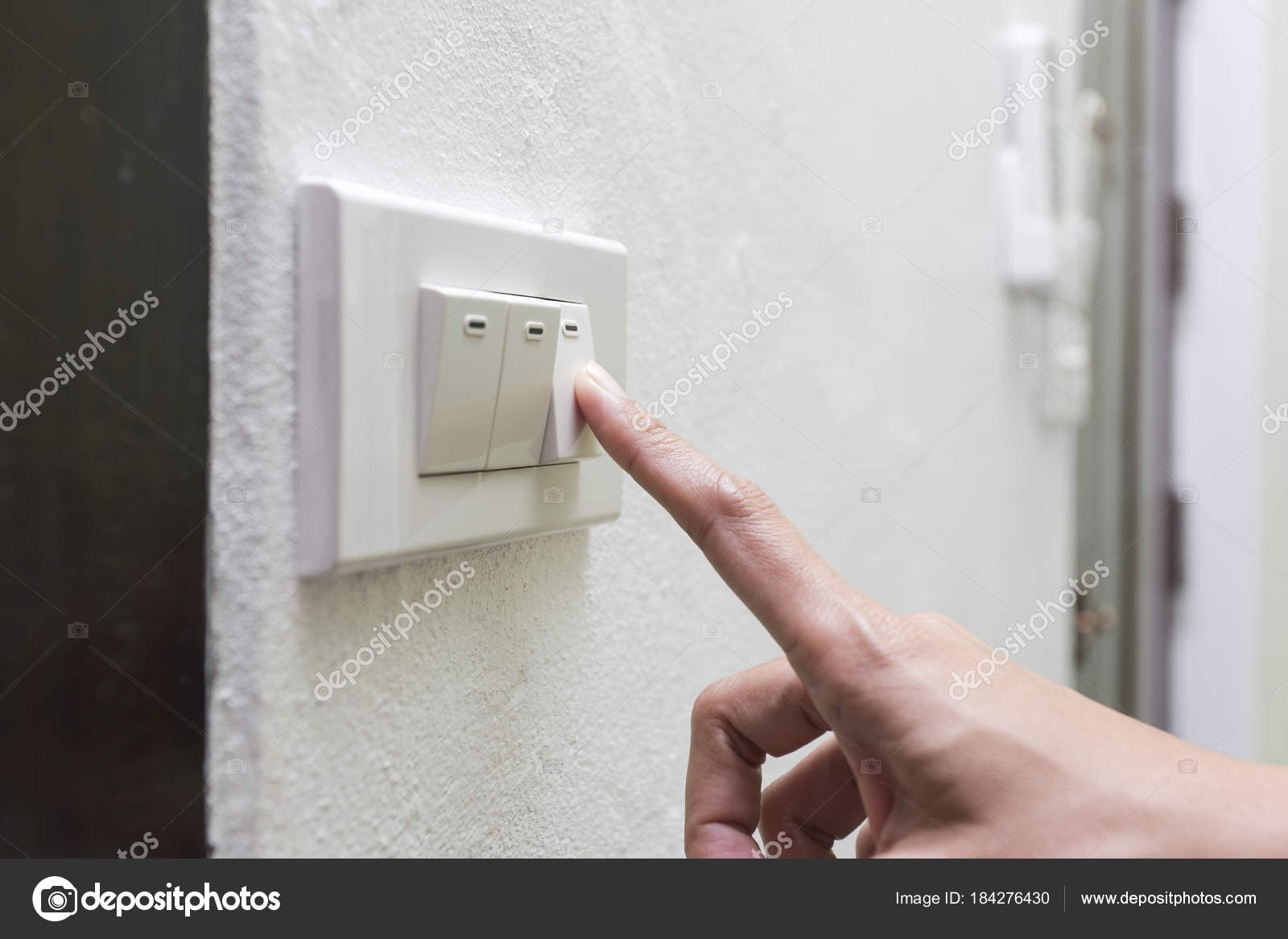 Woman turning off light switch in a home Stock Photo by ©Tatomm 184276430