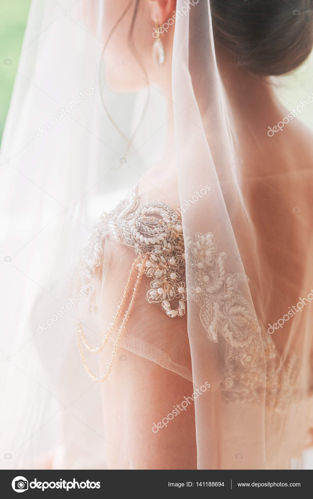 Beautiful young bride with wedding makeup and hairstyle in bedroom ...
