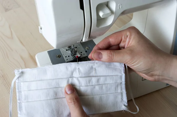 Handmade sewing mask, female hands, sew machine. close up. Protection ...