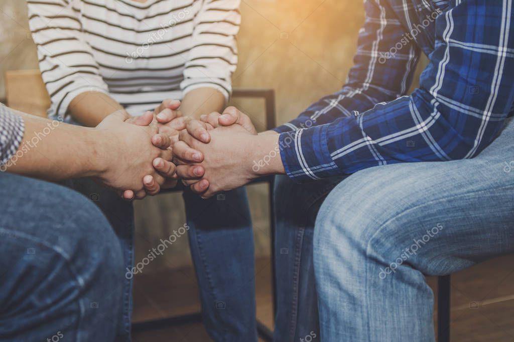 Grupo cristiano pequeño orando juntos alrededor de una mesa de madera ...