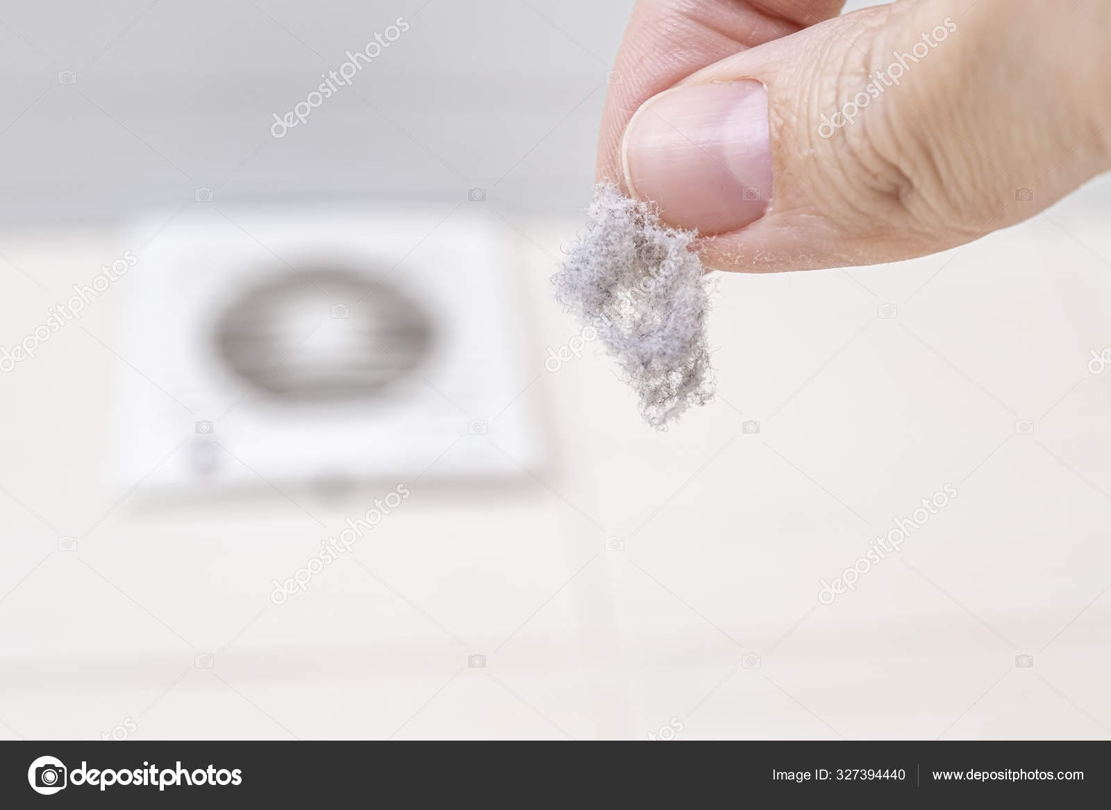 A hand holding dust ib fingers, dirty ventilaion frame on background ...